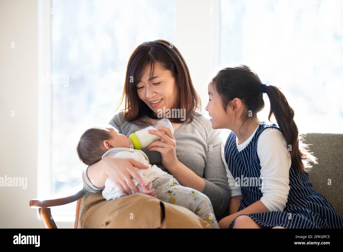 Parent and child feeding a baby Stock Photo - Alamy