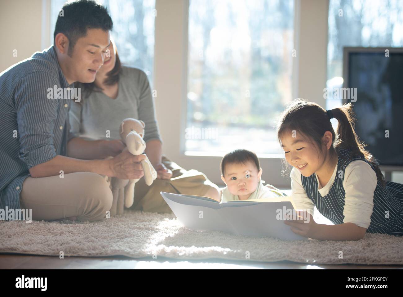 Family reading a storybook to their baby Stock Photo - Alamy