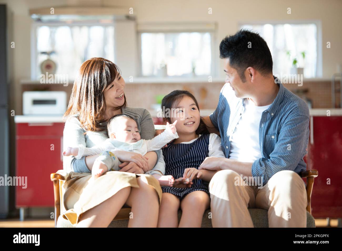Family sitting on the sofa chatting Stock Photo - Alamy