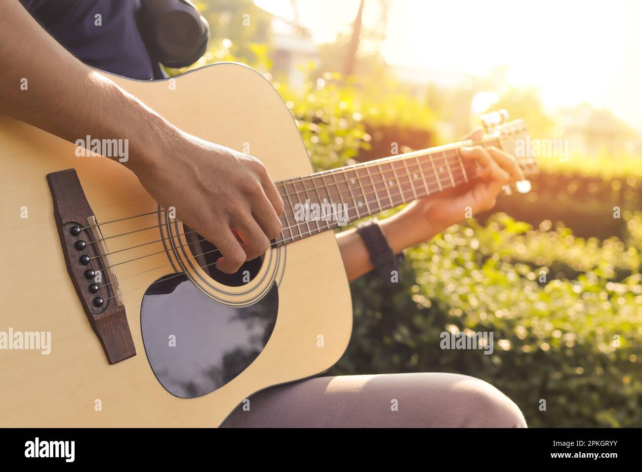 Close up of male hand playing guitar against sunlight during the ...