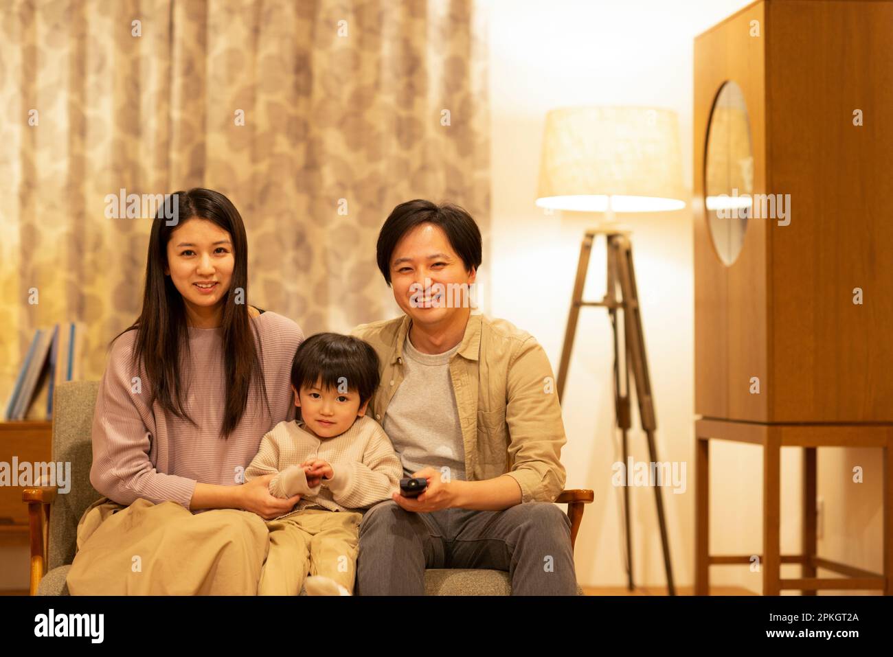 Parent and child sitting on the sofa watching TV Stock Photo - Alamy