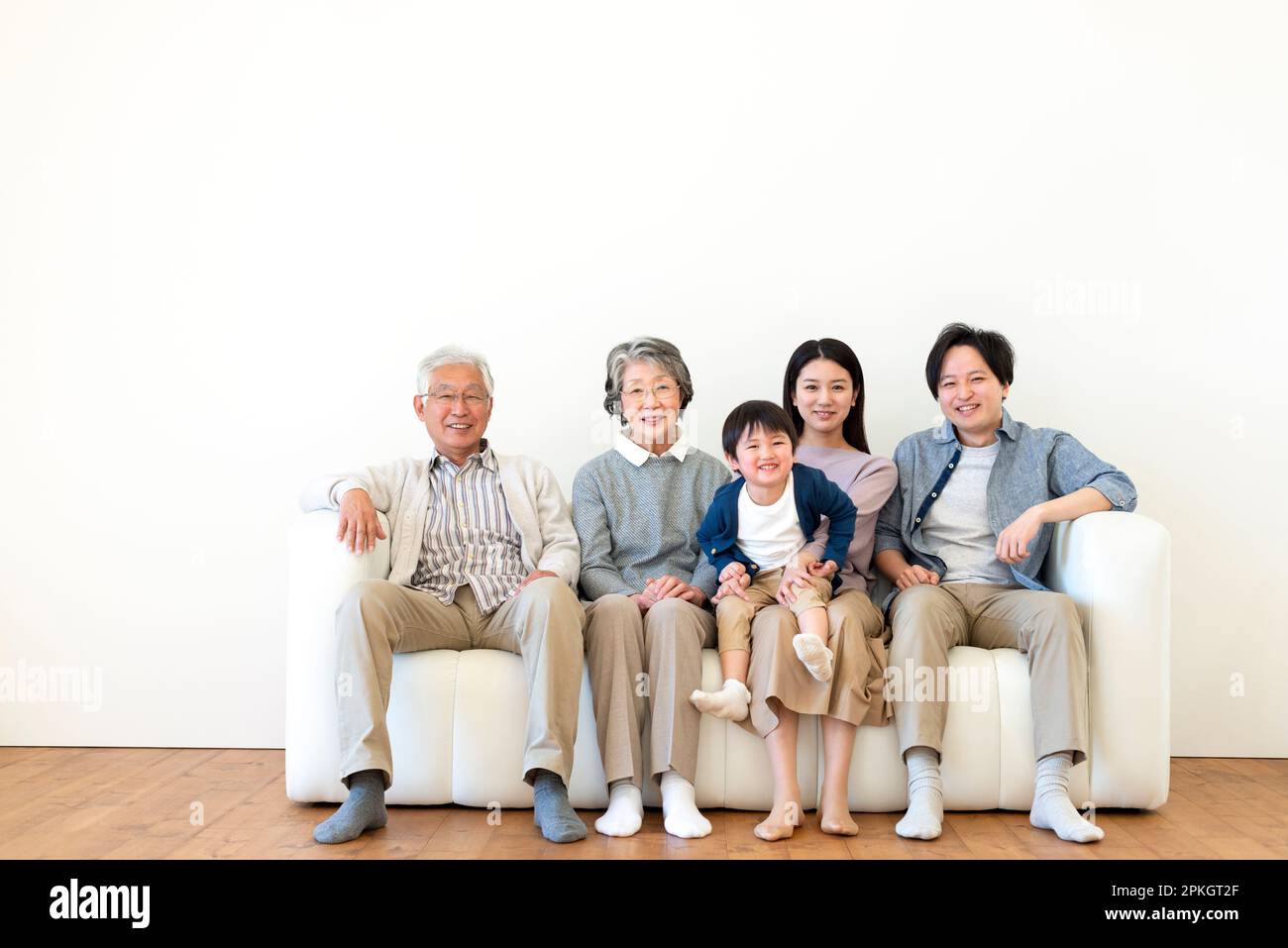 Family of 3 generations sitting on a sofa and smiling Stock Photo - Alamy
