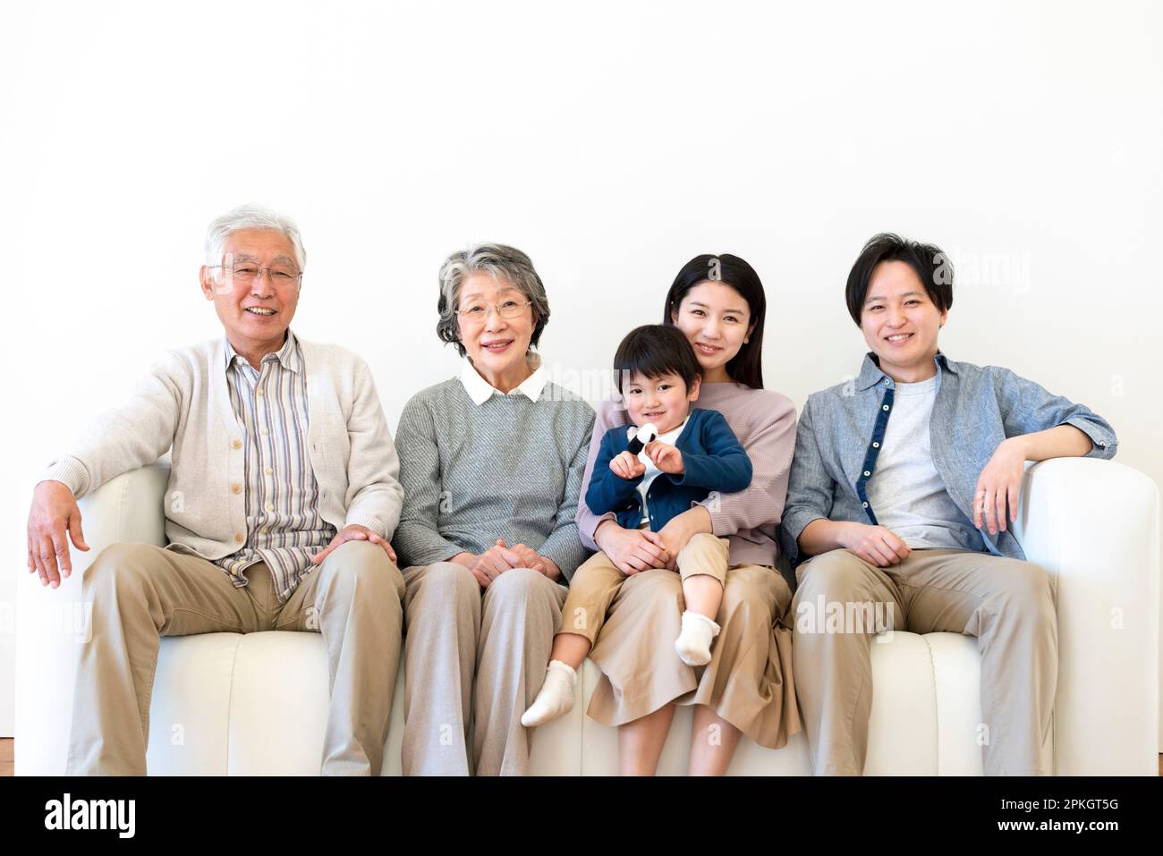 Family of 3 generations sitting and smiling on the sofa Stock Photo - Alamy