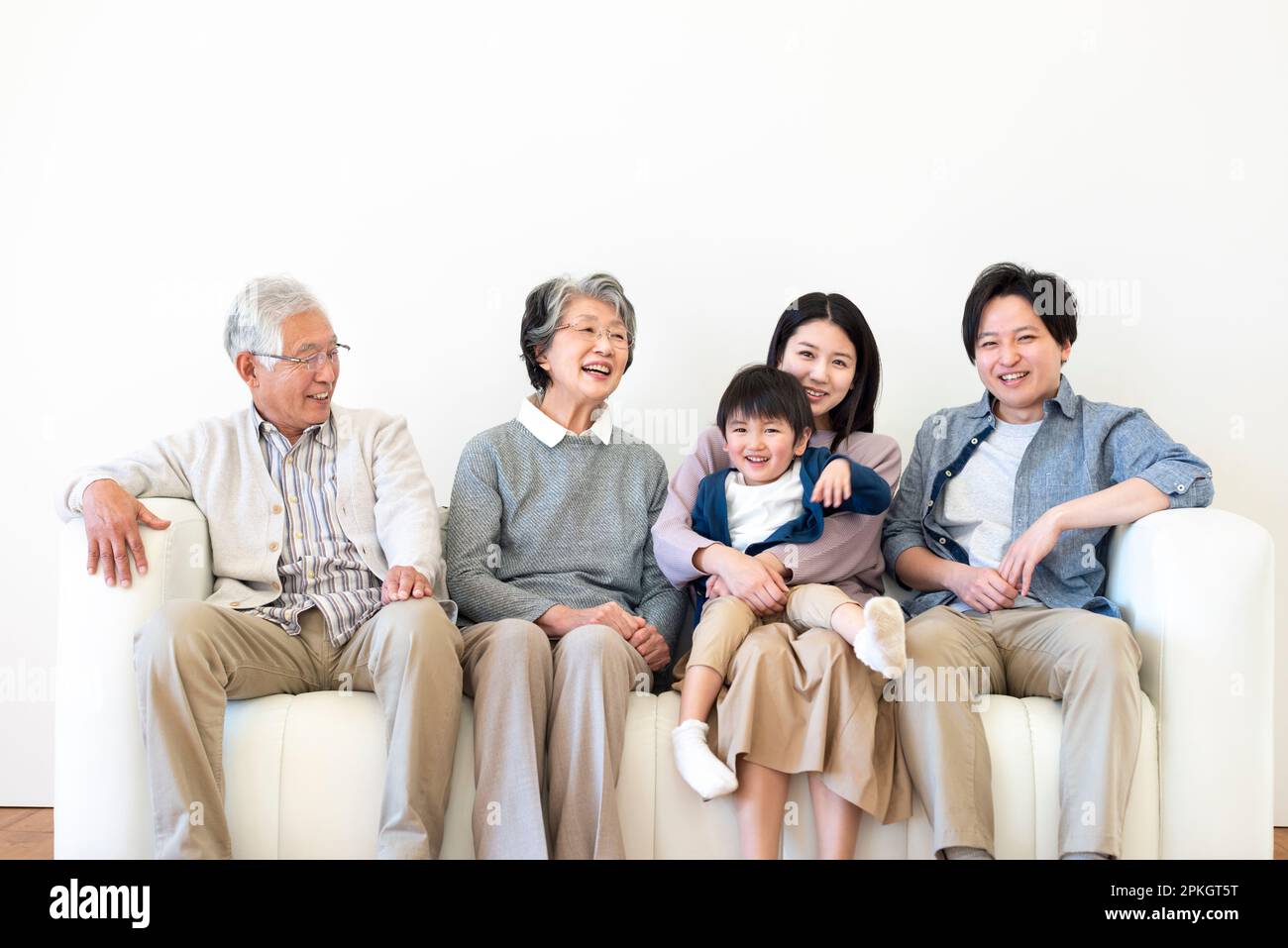 Family of 3 generations sitting and smiling on the sofa Stock Photo - Alamy