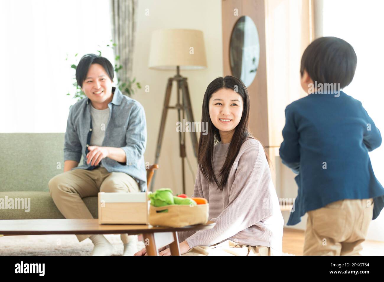 Parents watching their child running up to them Stock Photo - Alamy