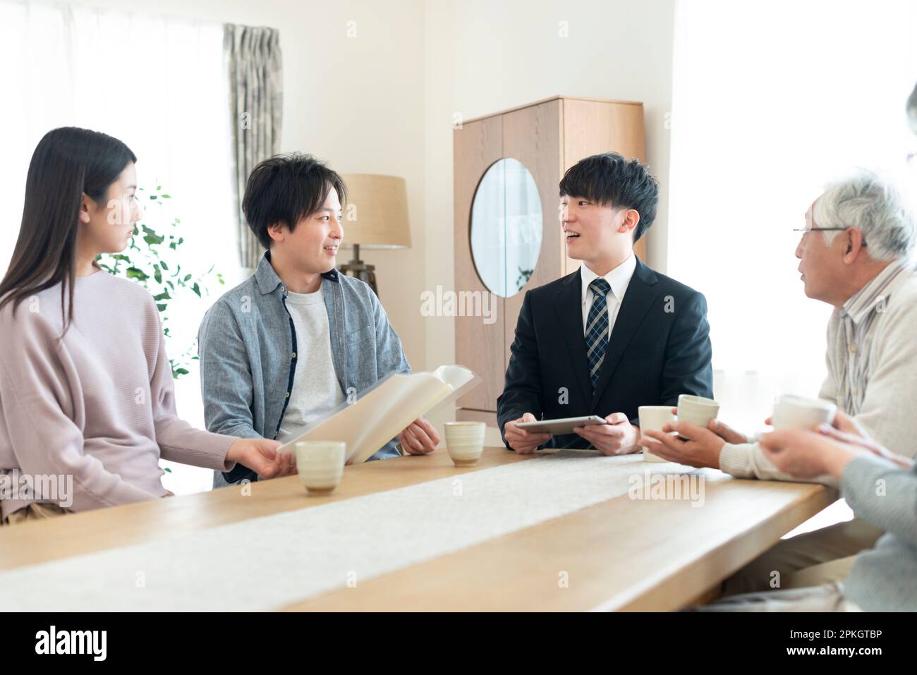 Family of 2 generations talking with a businessman Stock Photo - Alamy