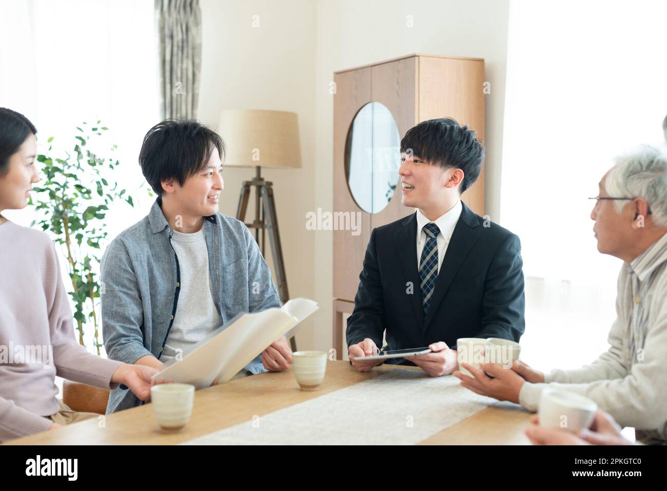 Family of 2 generations talking with a businessman Stock Photo - Alamy