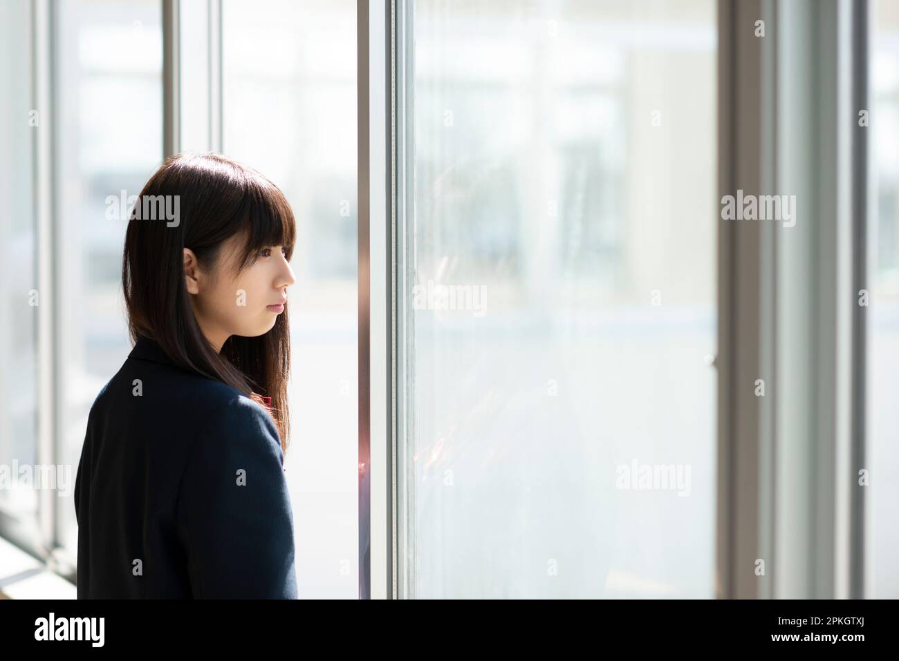 Female student by the window looking into the distance Stock Photo - Alamy