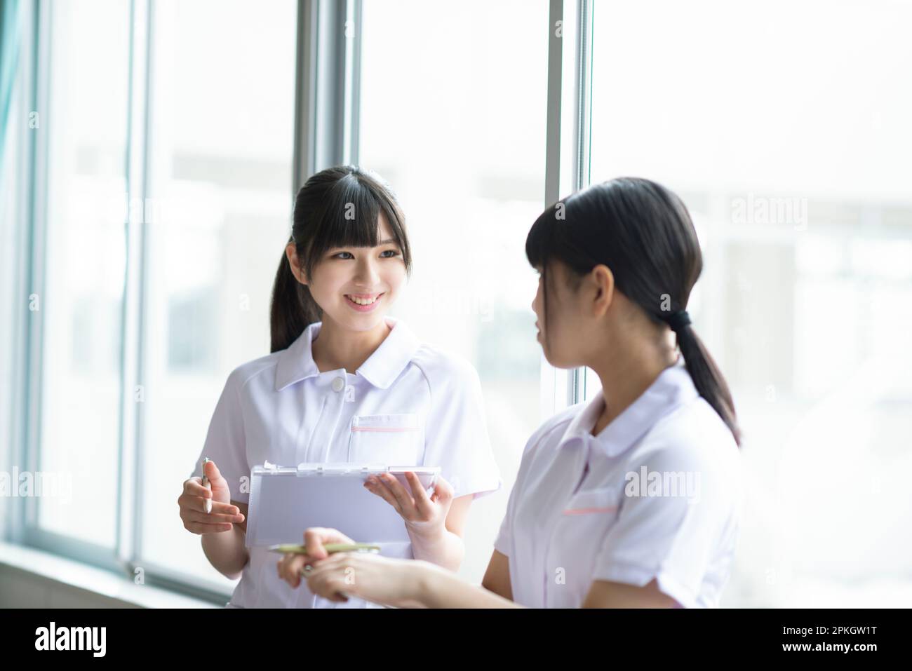 Nursing student chatting by the window Stock Photo - Alamy