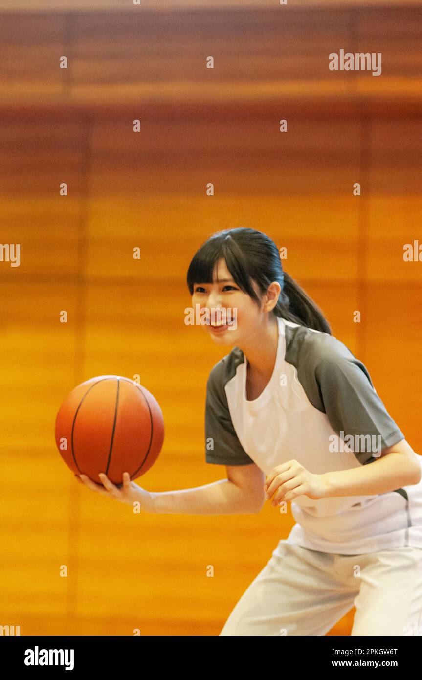 Female student playing basketball in gymnasium Stock Photo - Alamy