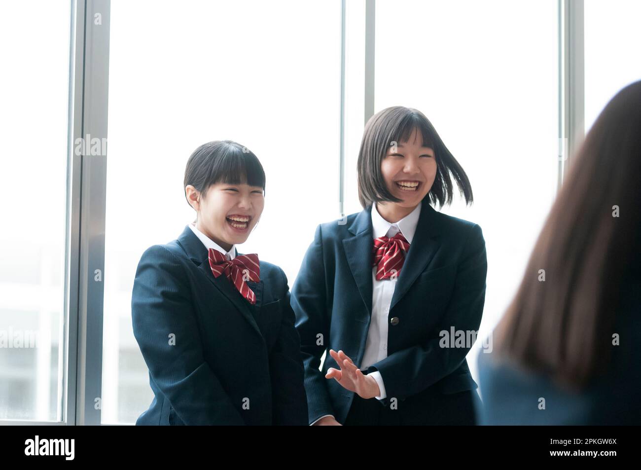 Female students chatting by the window Stock Photo - Alamy