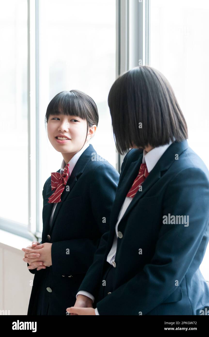 Female students chatting by the window Stock Photo - Alamy