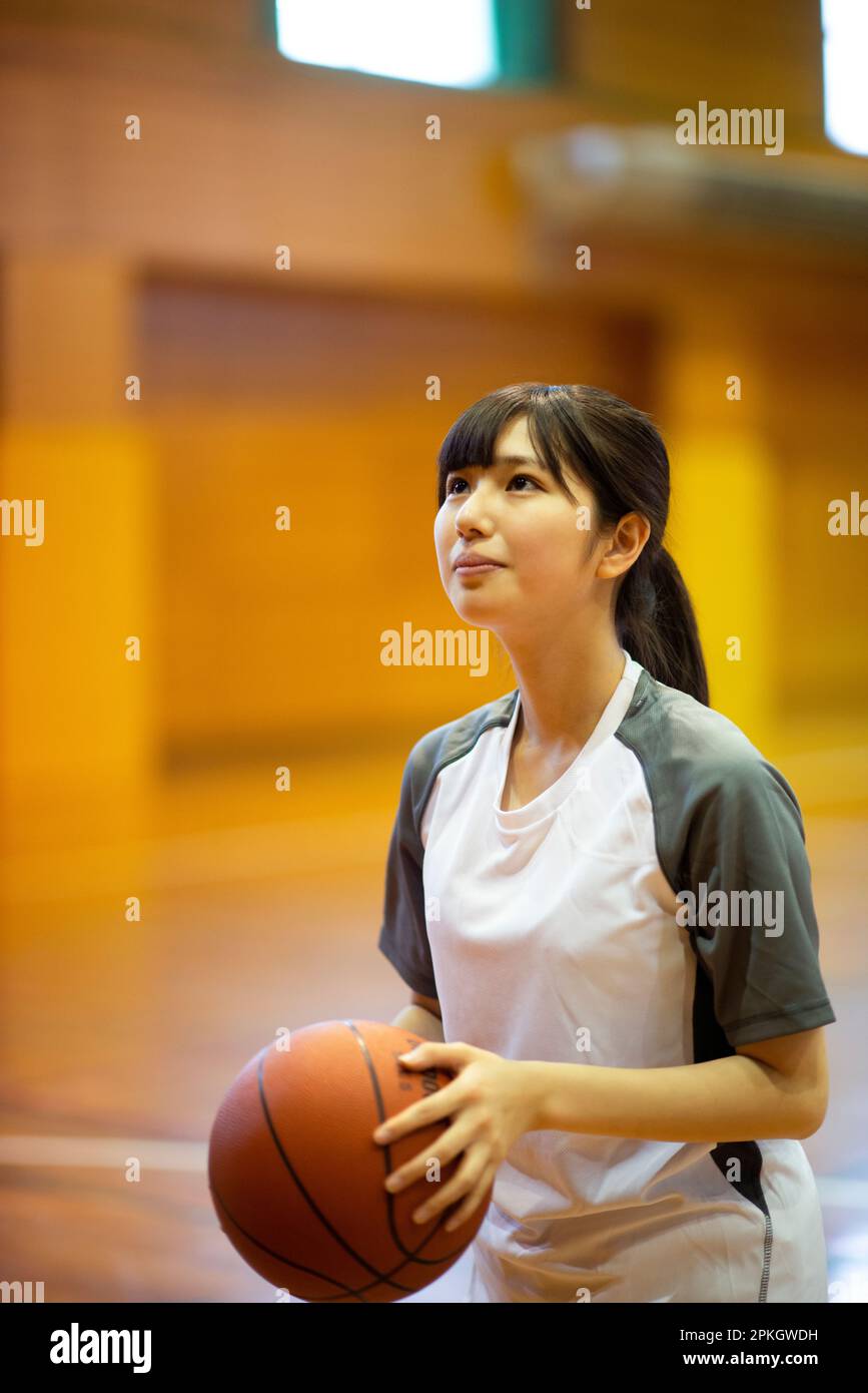 Female student playing basketball in the gym Stock Photo - Alamy