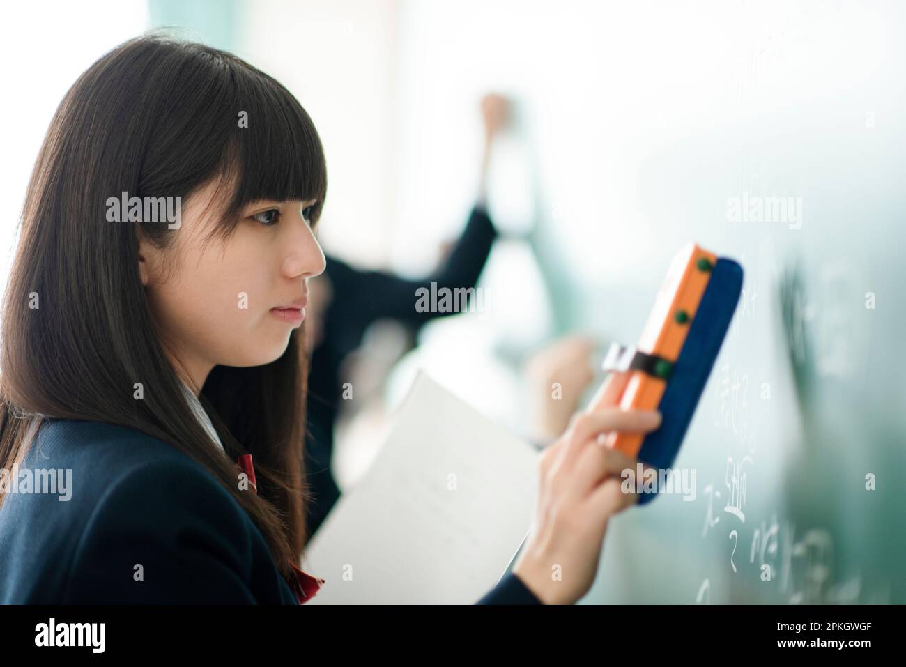 Female student holding a blackboard eraser Stock Photo - Alamy
