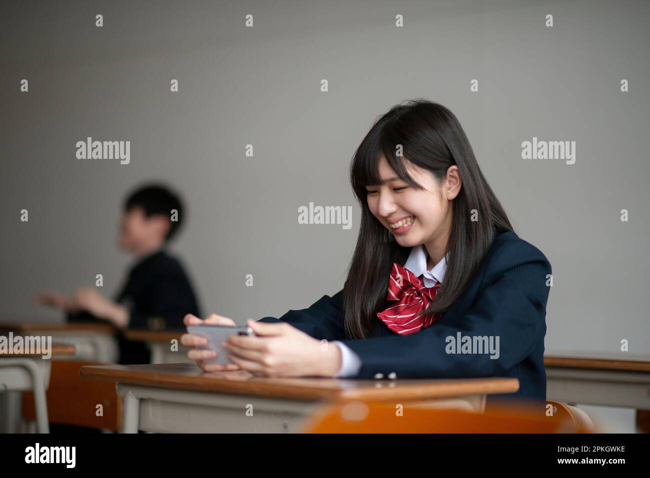Female student looking at her smartphone in the classroom Stock Photo ...