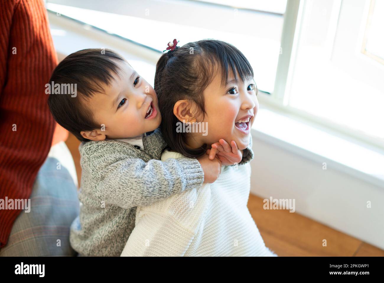 Little brother hugging his sister Stock Photo - Alamy