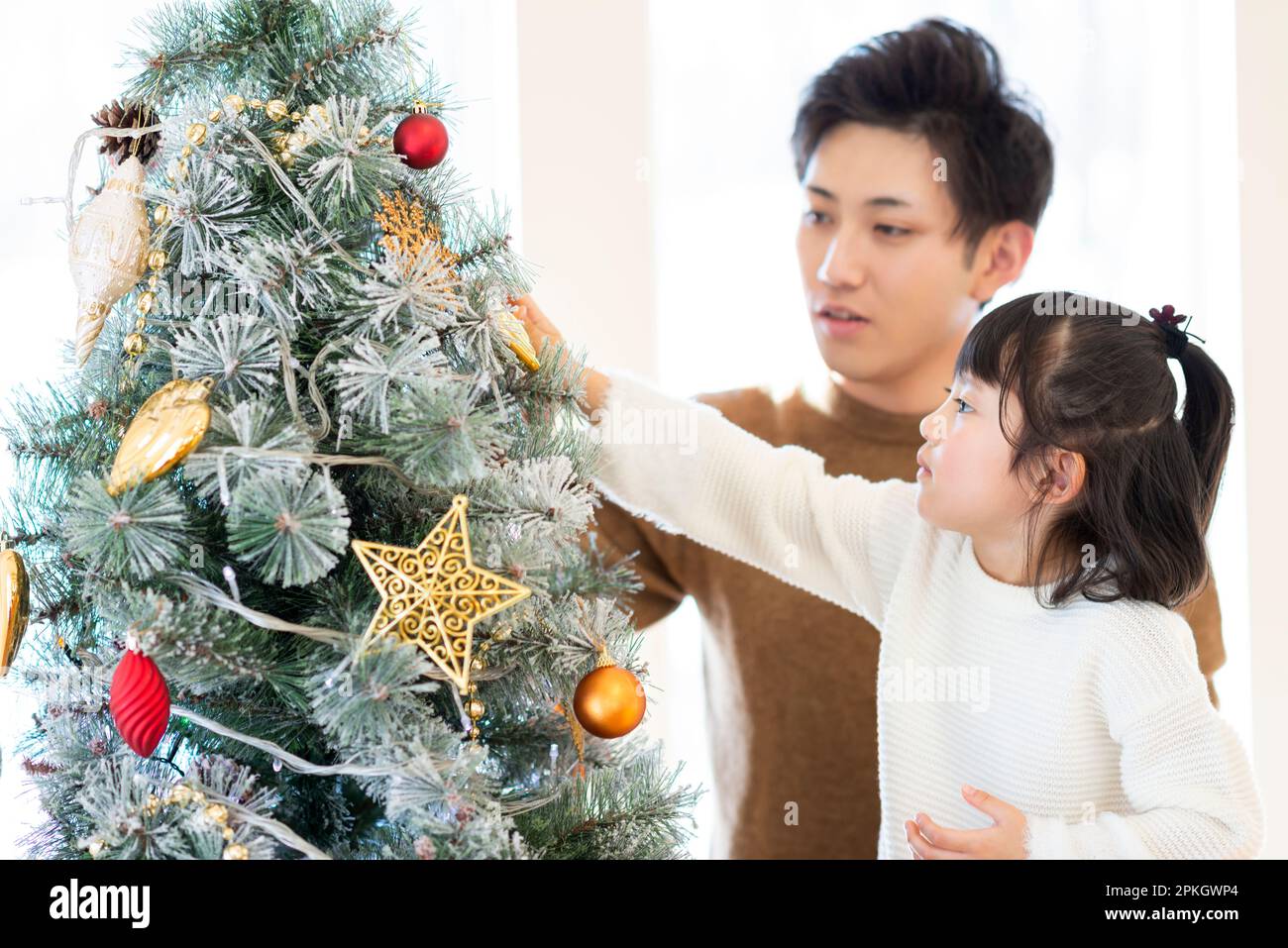Parent and child decorating Christmas tree Stock Photo - Alamy