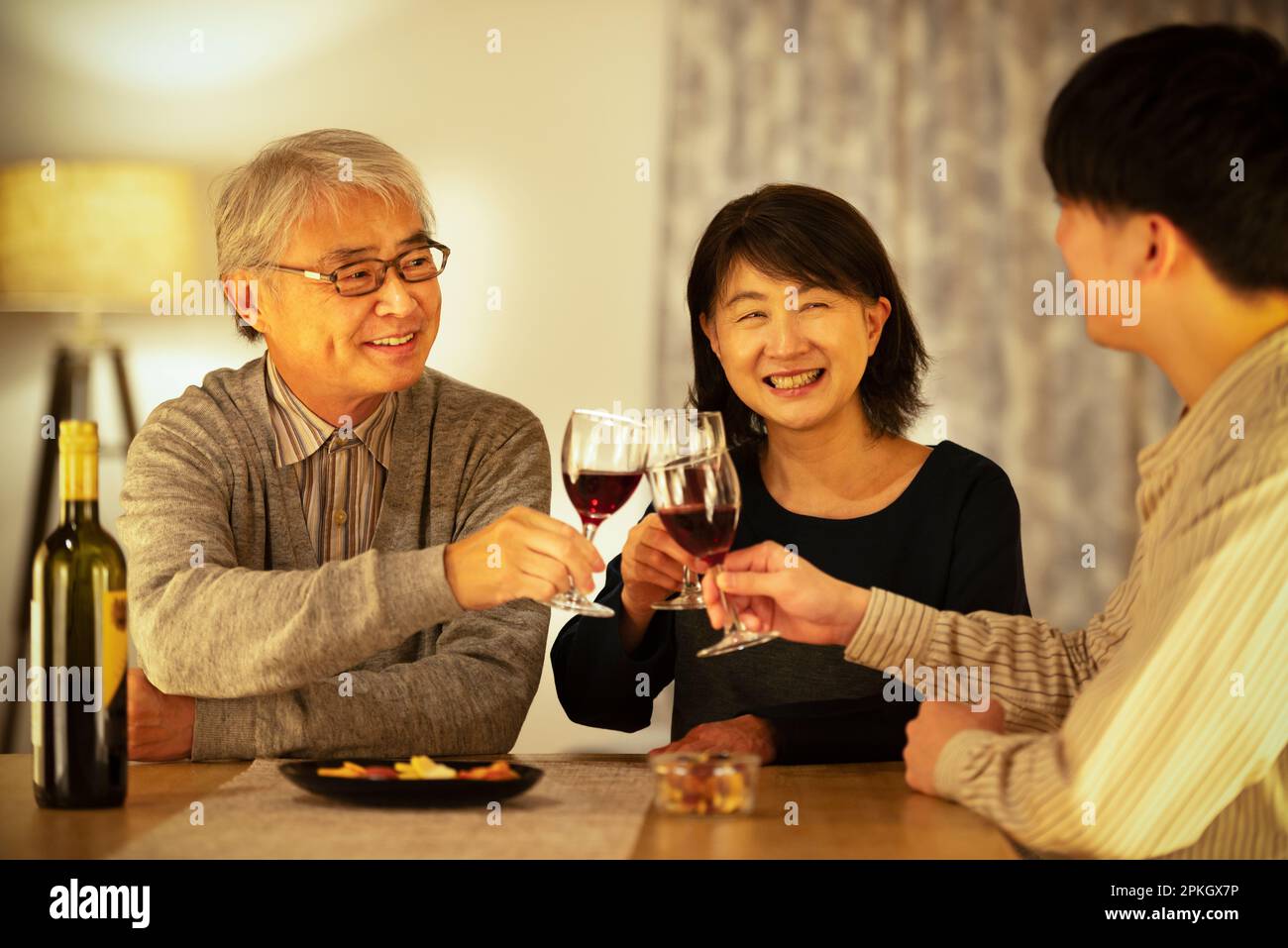 Parents and children toasting wine Stock Photo - Alamy
