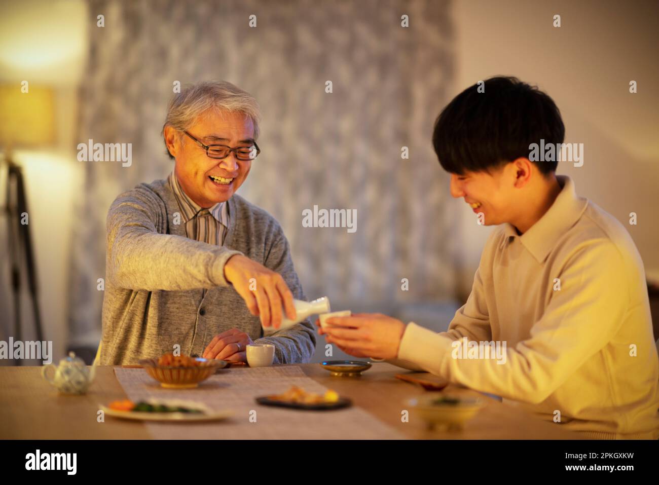 Parents and children drinking sake together in the evening Stock Photo ...