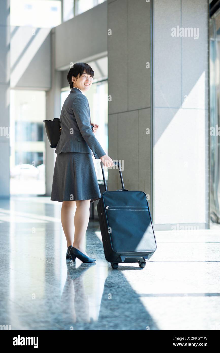 Pulling woman on suitcase hi-res stock photography and images - Alamy