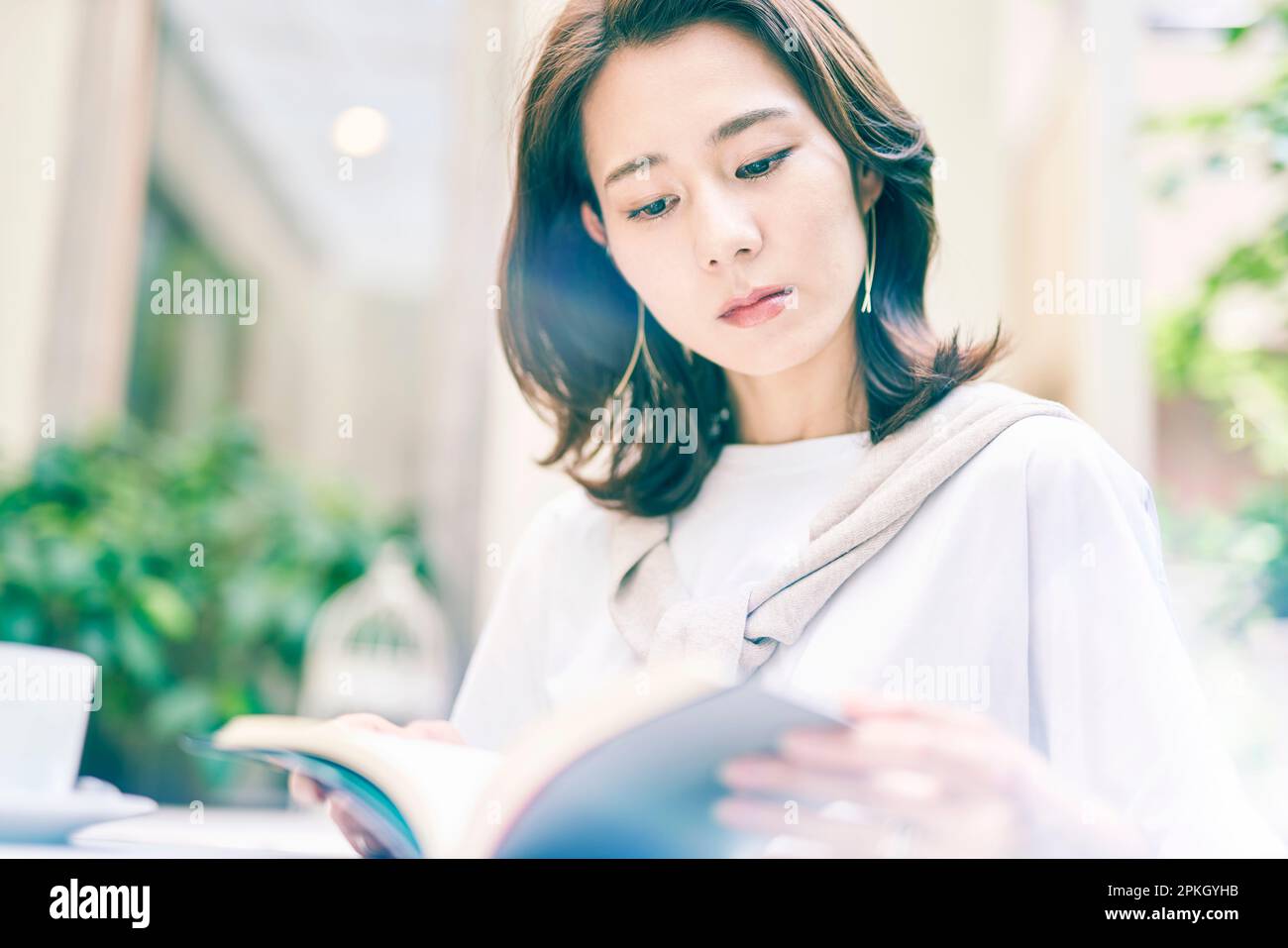Woman reading at cafe Stock Photo - Alamy