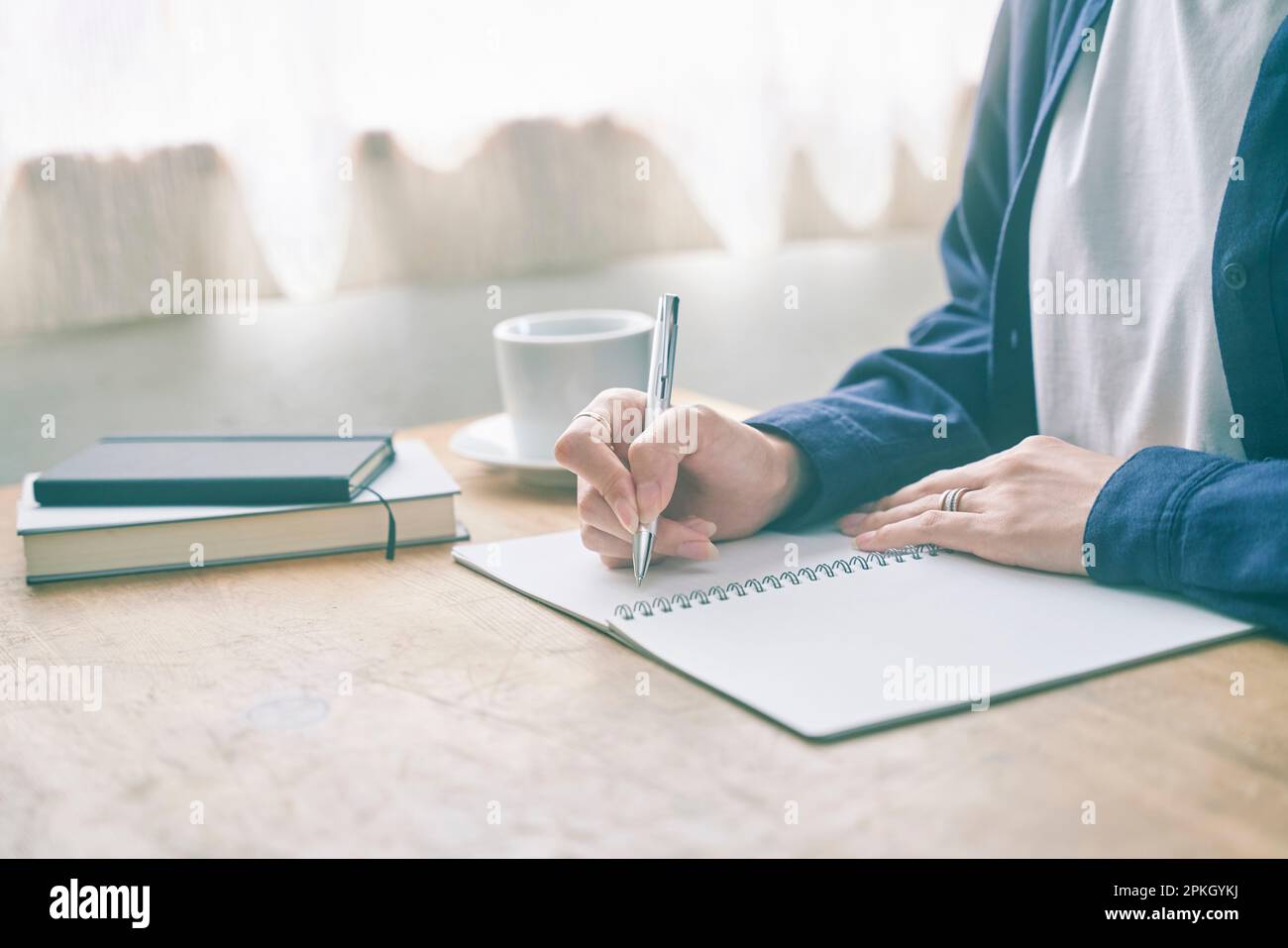 Woman writing notes at a café Stock Photo - Alamy