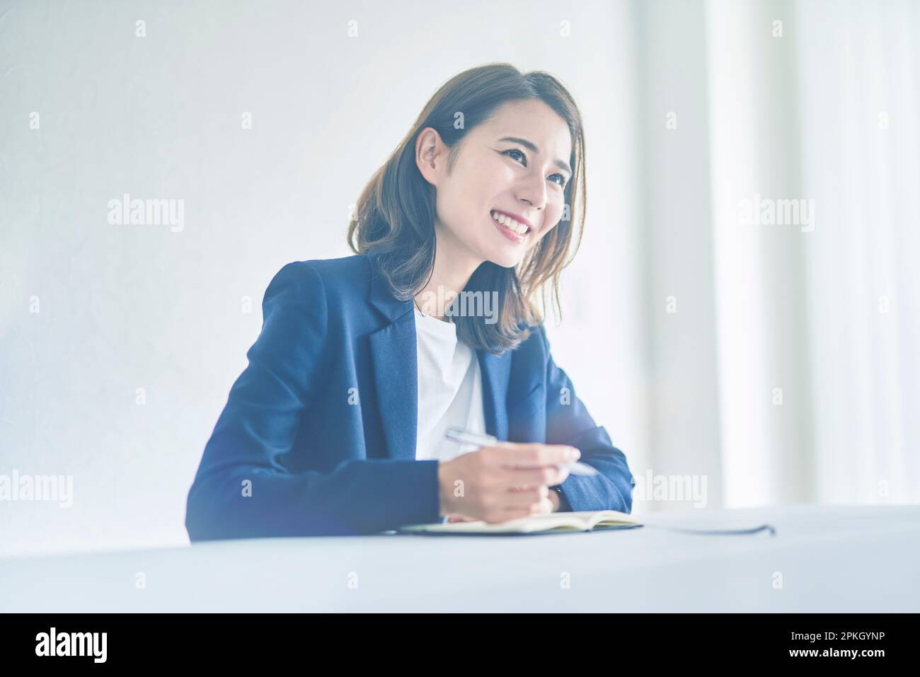 Woman taking notes with a smile Stock Photo - Alamy