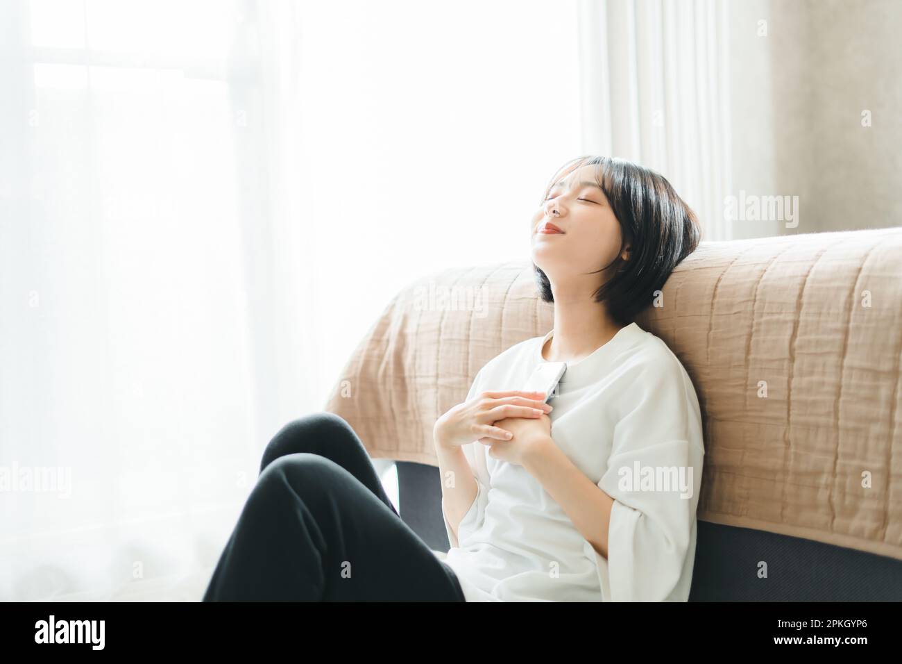 Woman holding mobile phone to chest hi-res stock photography and images ...