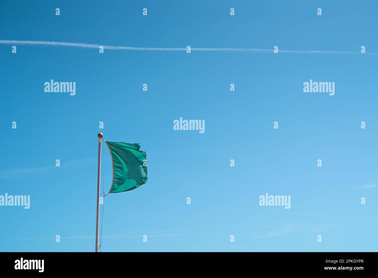 Green flag on the beach Stock Photo - Alamy