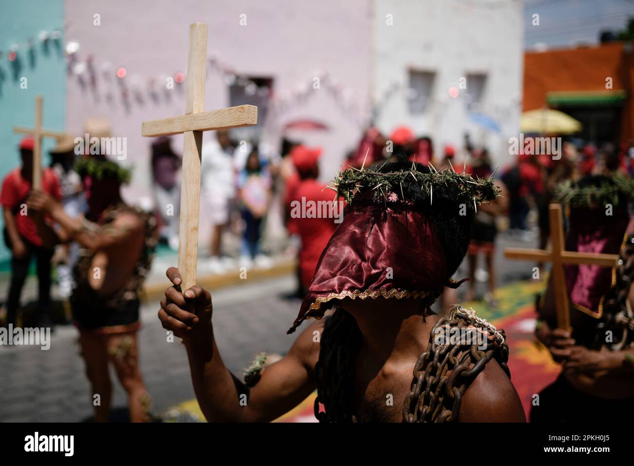 Masked penitents in chains with cacti stuck to their skin, march during ...