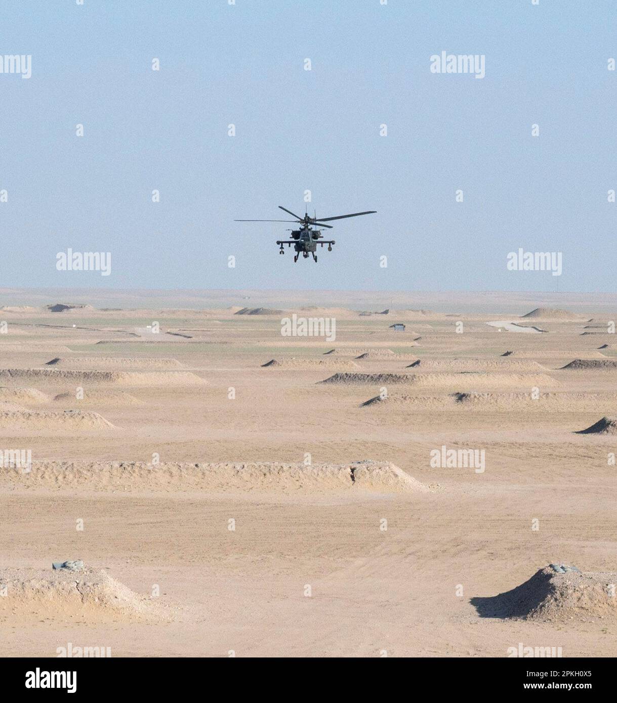 A U.S. Army AH-64 Apache flies over the range during training at Udairi ...