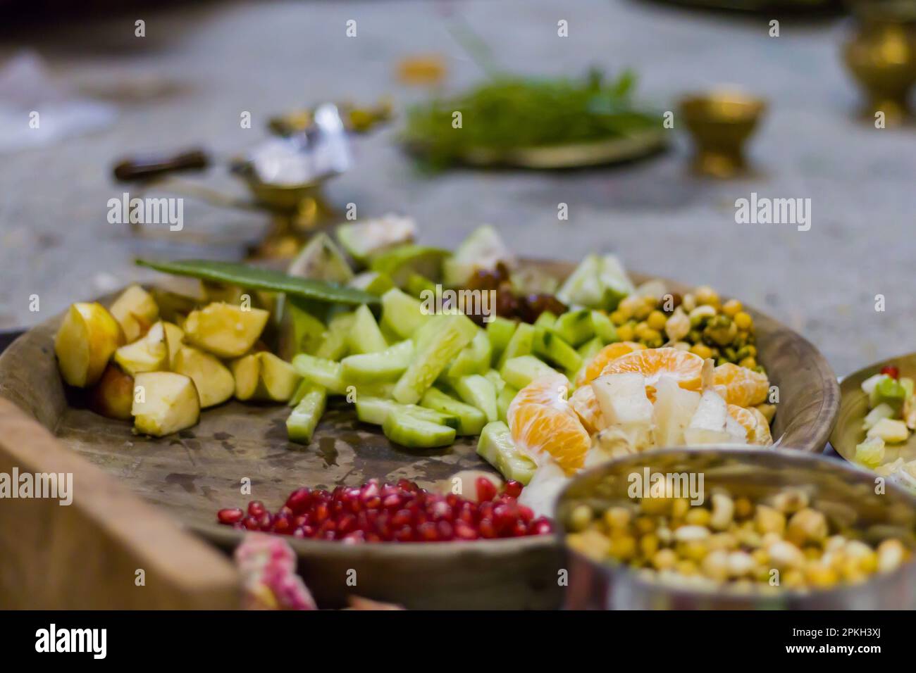 Various fruits and vegetables are kept together in brass plates for ...