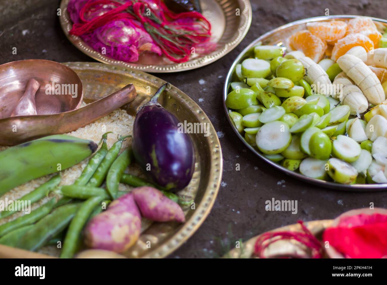 Various fruits and vegetables are kept together in brass plates for ...