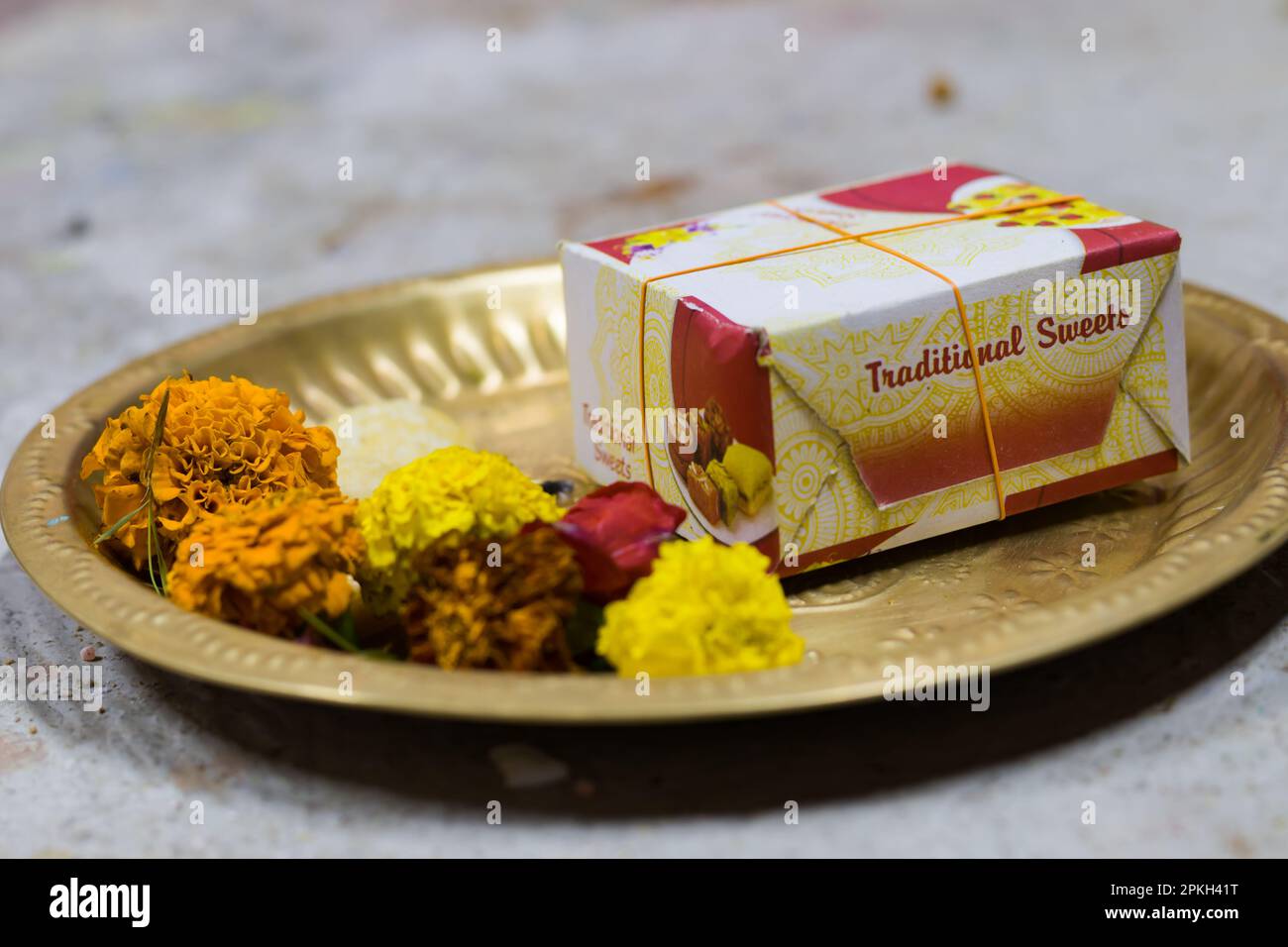 Sweet box and colorful marigold flowers kept on a brass plate for ...
