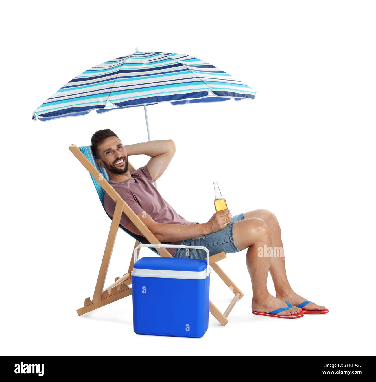 Happy man with bottle of beer resting in deck chair near cool box on ...