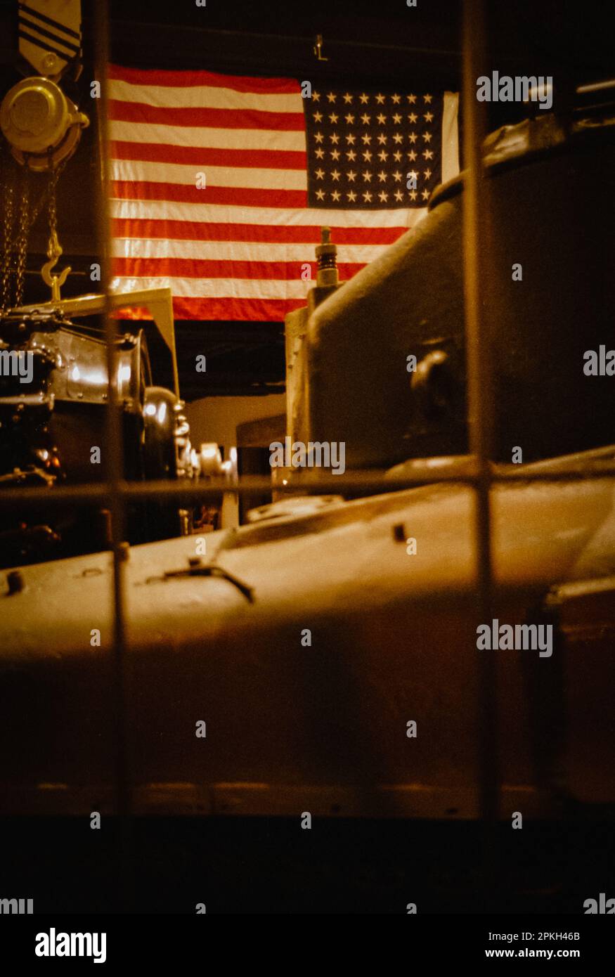 A view through a bared window were an American flag hangs behind ...