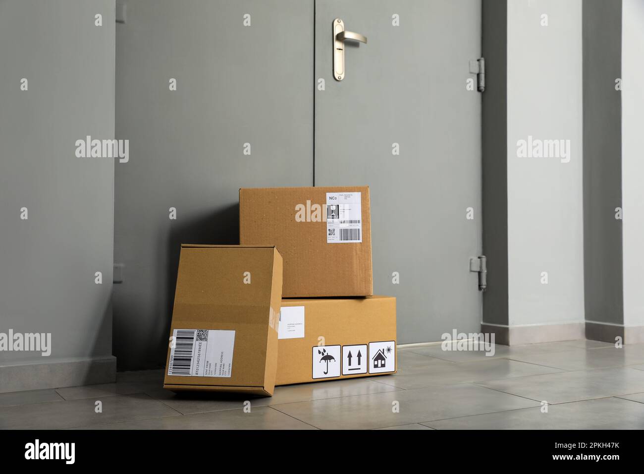 Cardboard boxes on floor near entrance. Parcel delivery service Stock ...