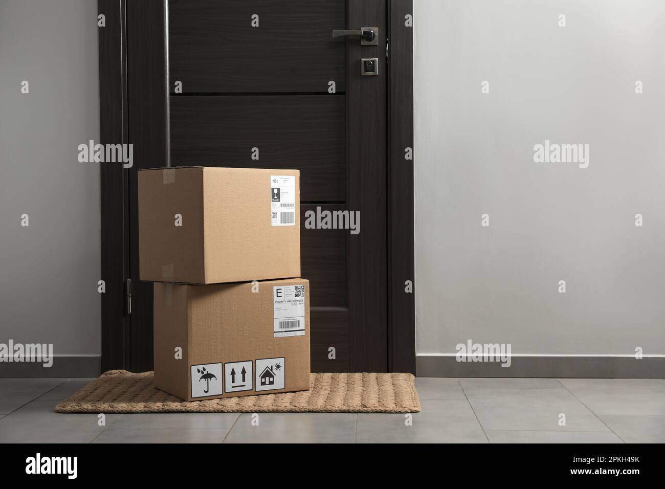 Cardboard boxes on floor mat near entrance. Parcel delivery service ...