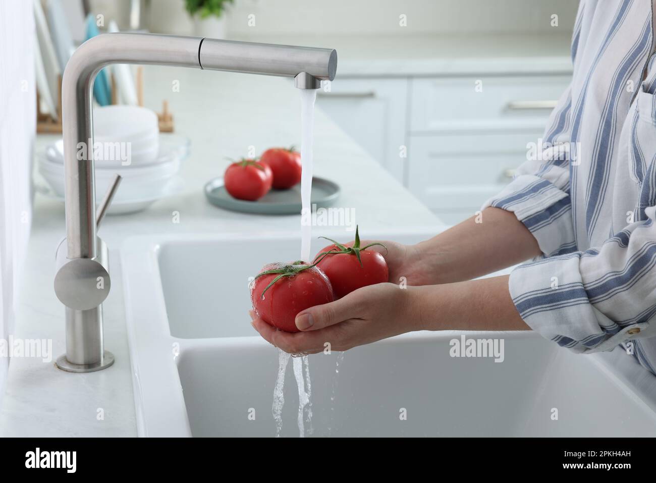 Female washing vegetables under tap hi-res stock photography and images ...
