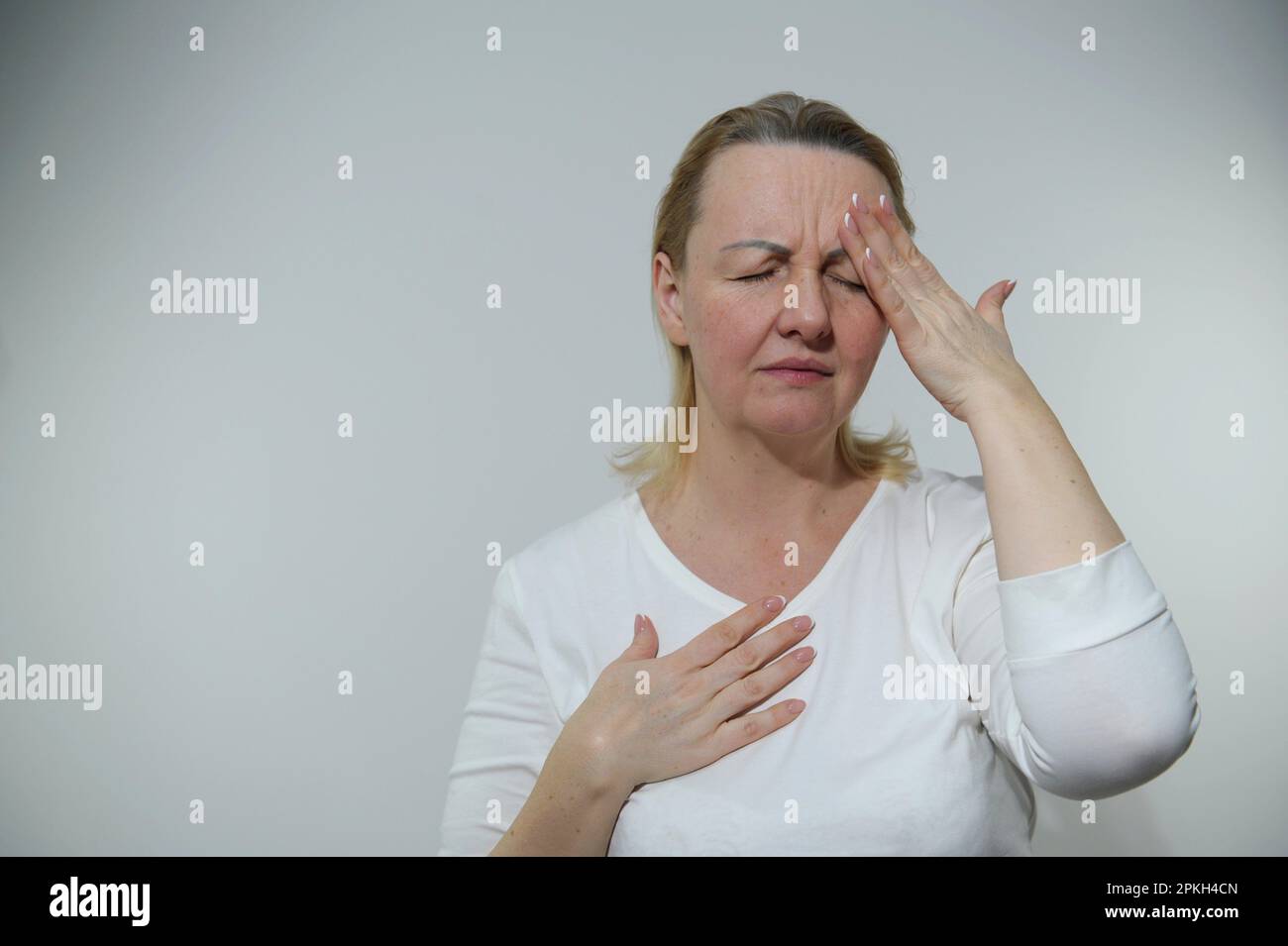 Upset stressed older woman holds head with hands sit on sofa near ...