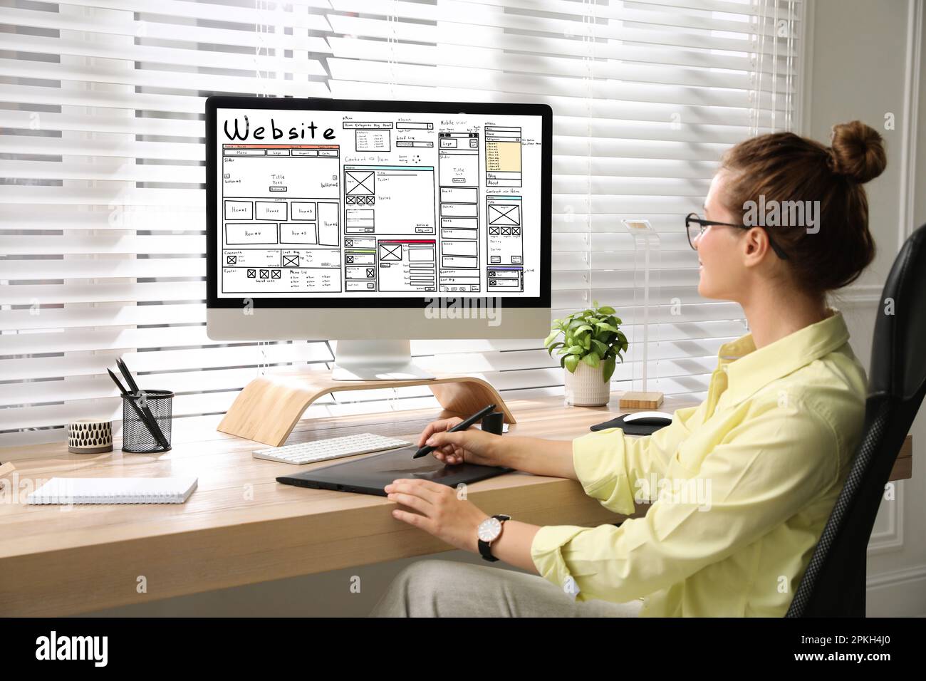 Designer creating website on computer at wooden table Stock Photo - Alamy