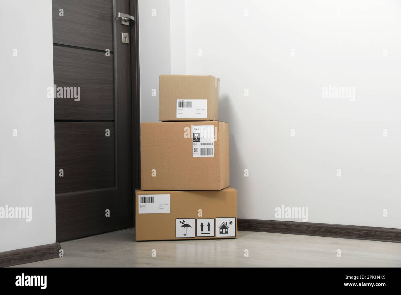 Cardboard boxes on floor near entrance. Parcel delivery service Stock ...