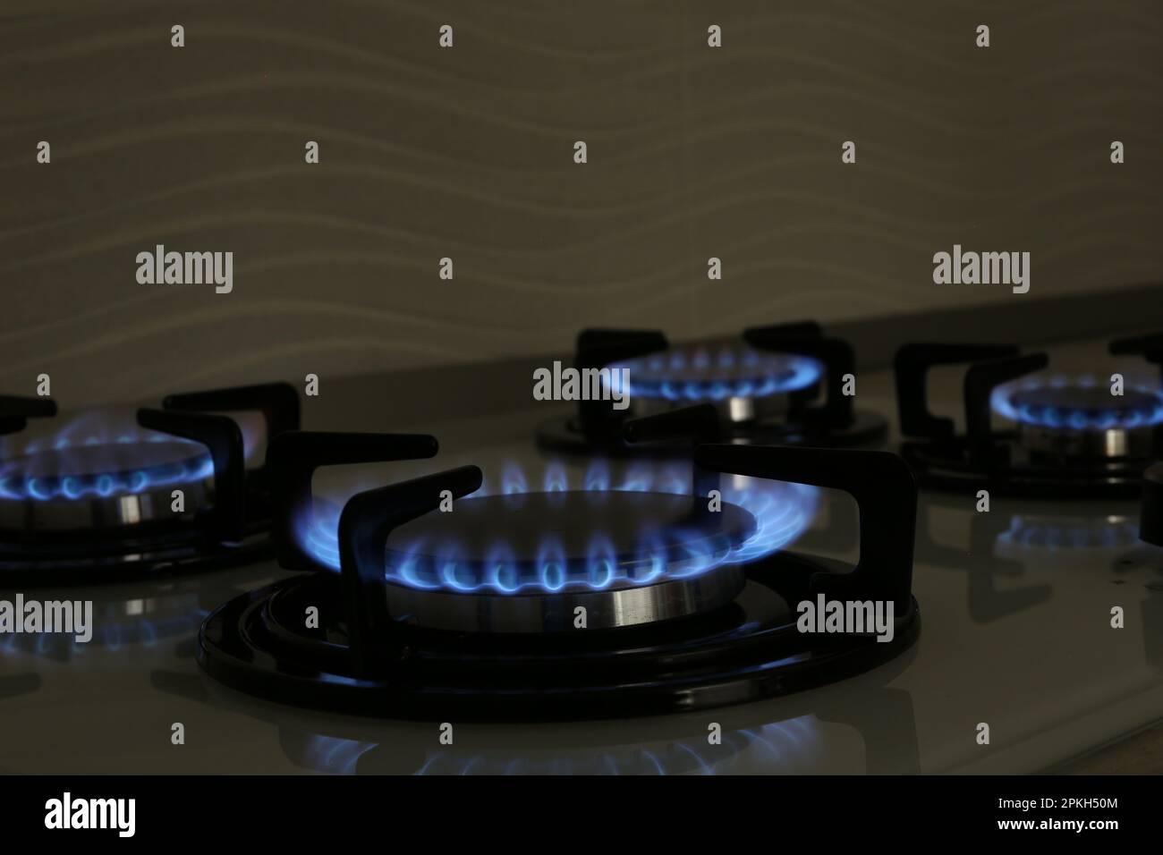 Modern gas cooktop with burning blue flames in kitchen Stock Photo - Alamy