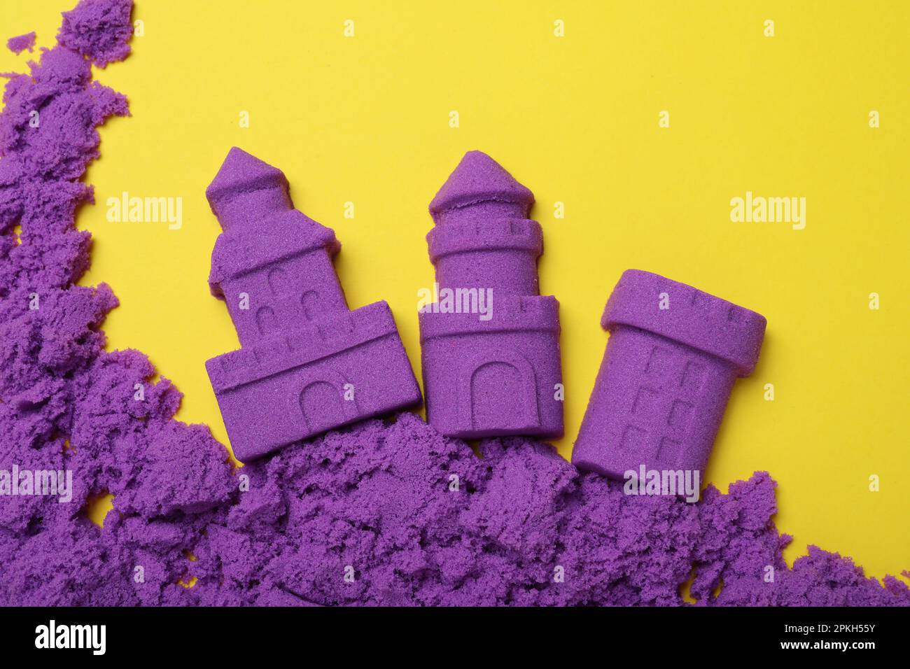 Castles made of kinetic sand on yellow background, flat lay Stock Photo ...