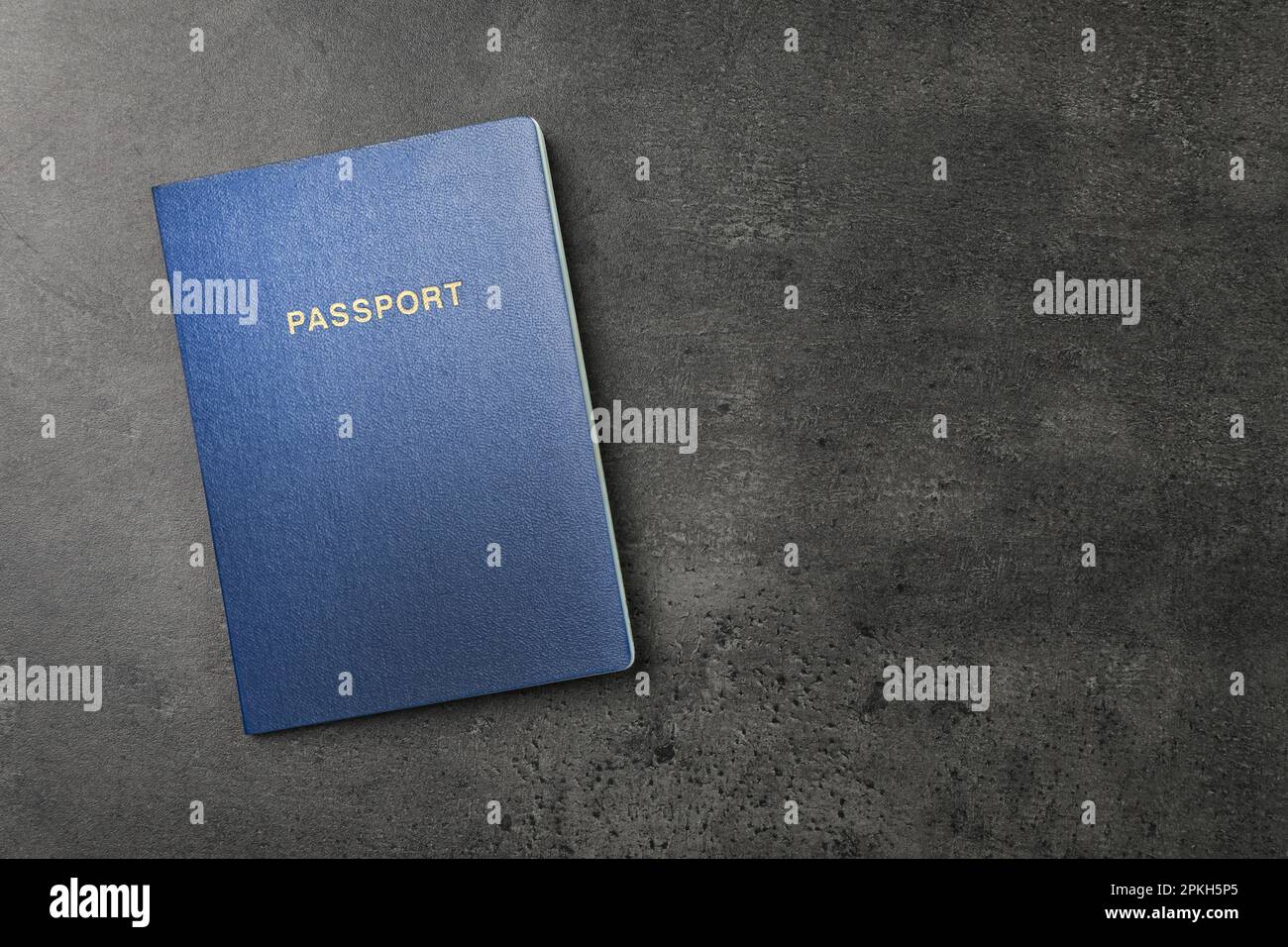 Blank blue passport on dark grey table, top view with space for text ...