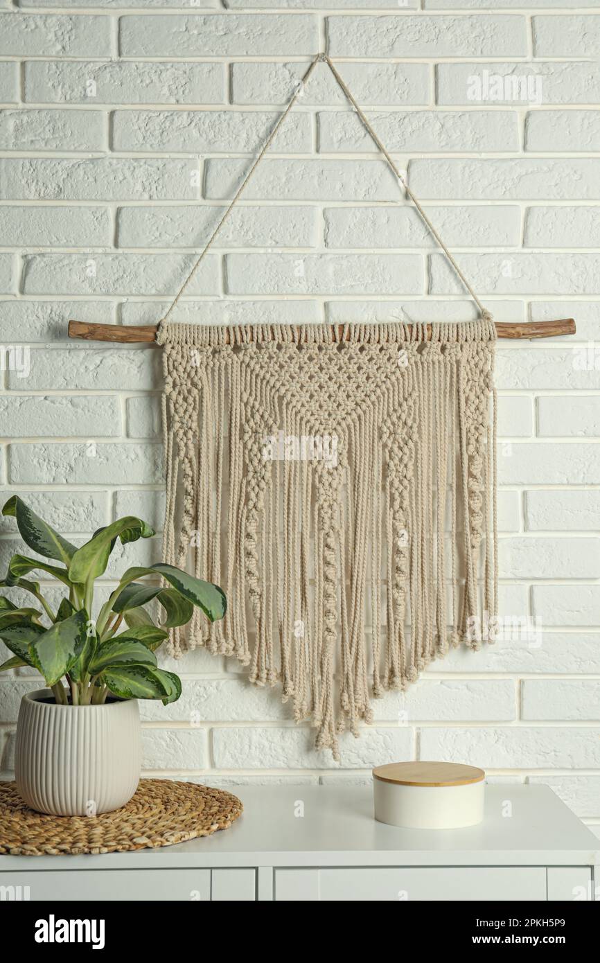 Beautiful macrame hanging on white brick wall in room. Decorative ...