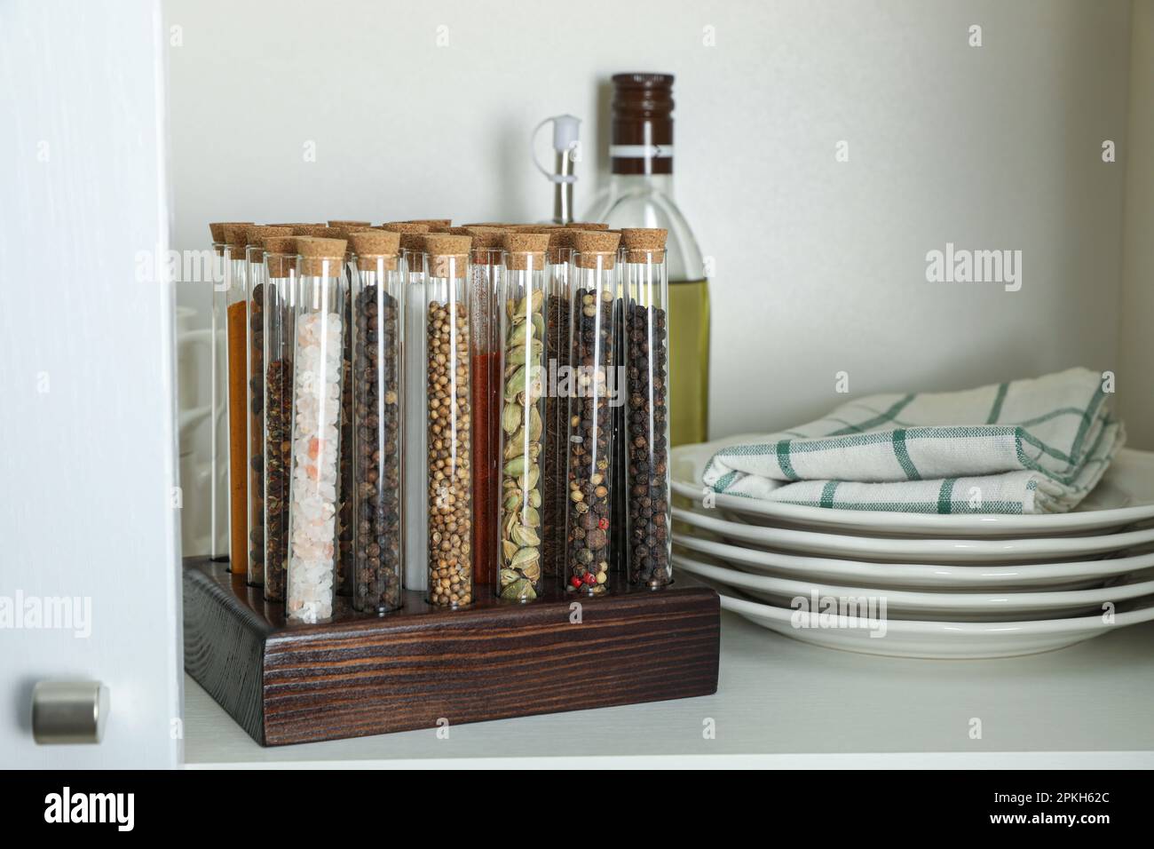 Glass tubes with different spices in kitchen cabinet Stock Photo - Alamy