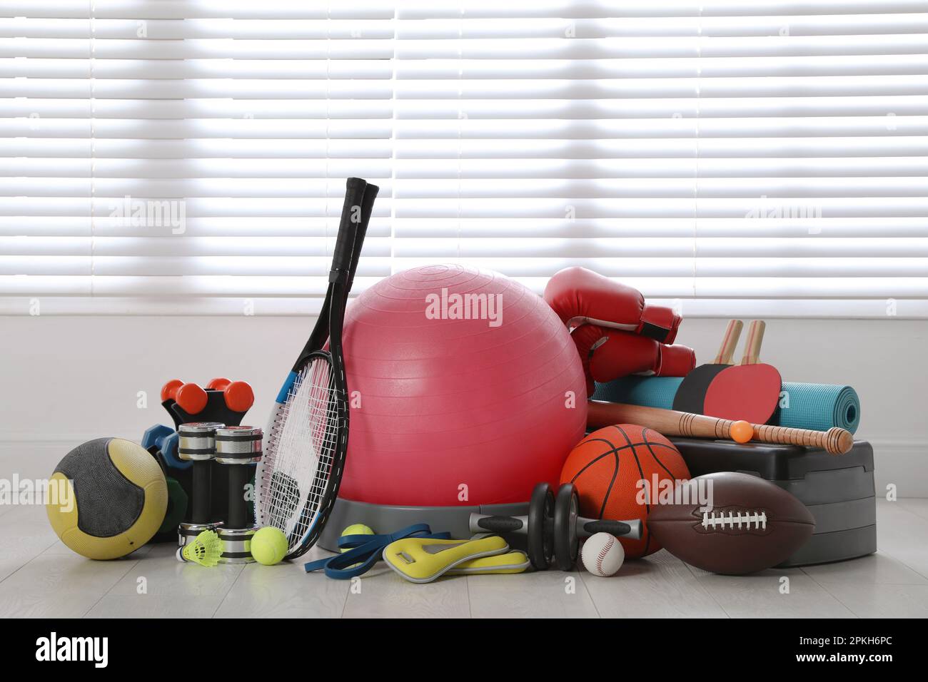 Set of different sports equipment on white floor indoors Stock Photo ...