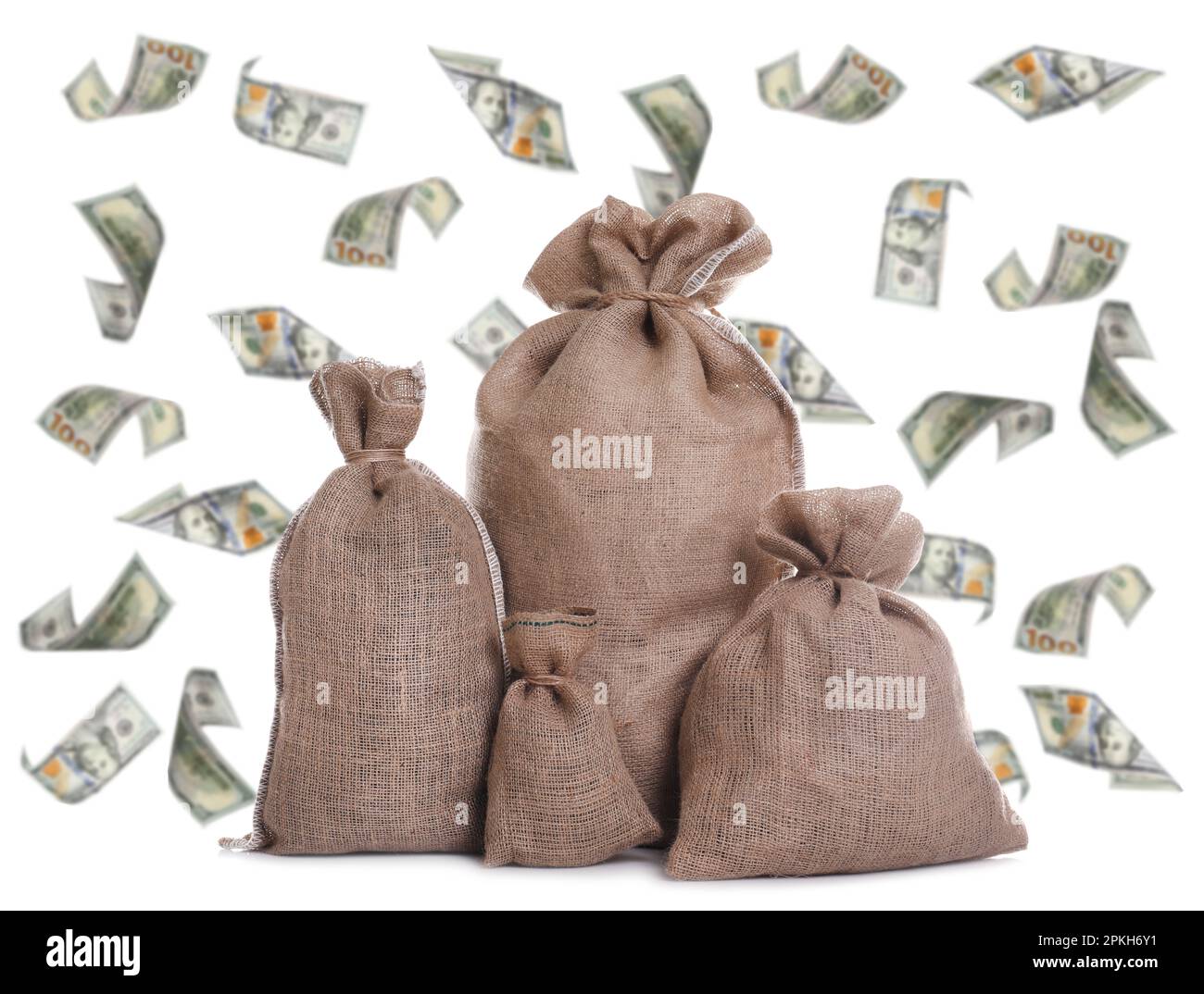 Burlap bags and flying dollar banknotes on white background Stock Photo ...
