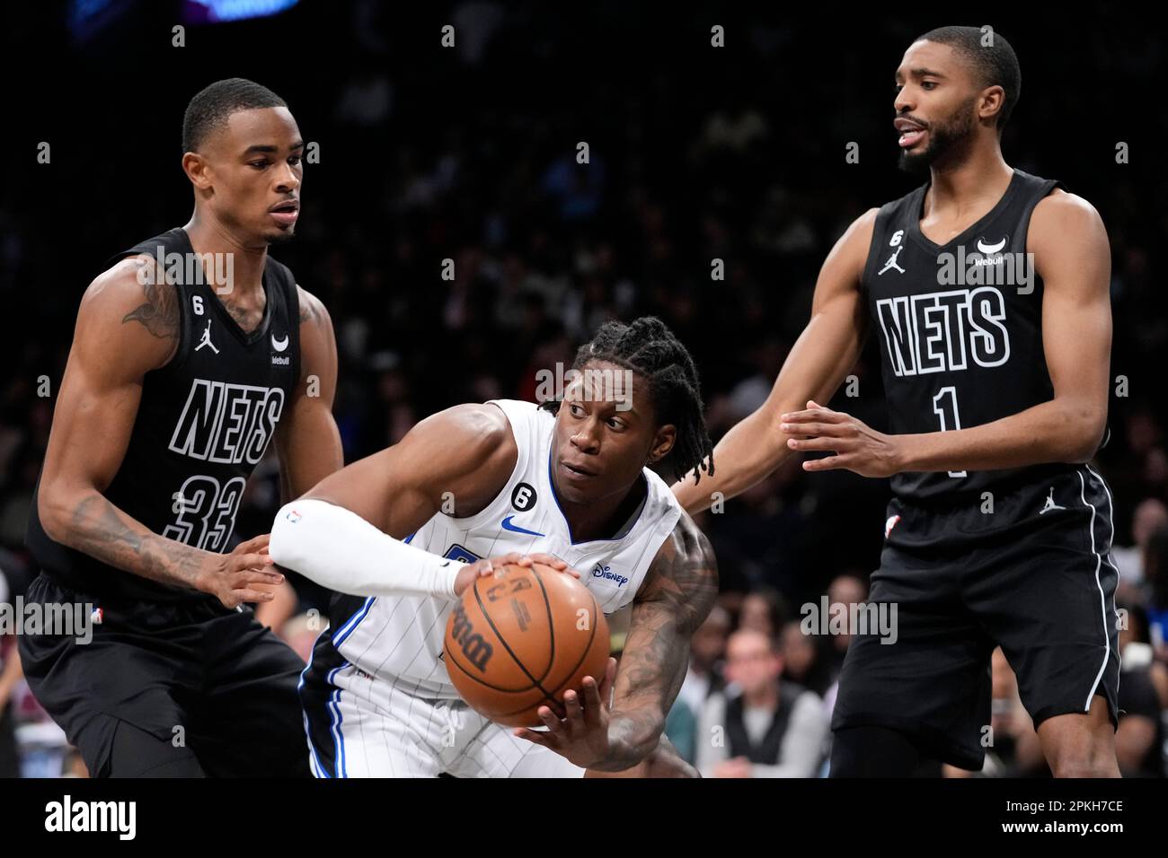 Orlando Magic forward Admiral Schofield, center, is defended by Brooklyn Nets center Nic Claxton ...